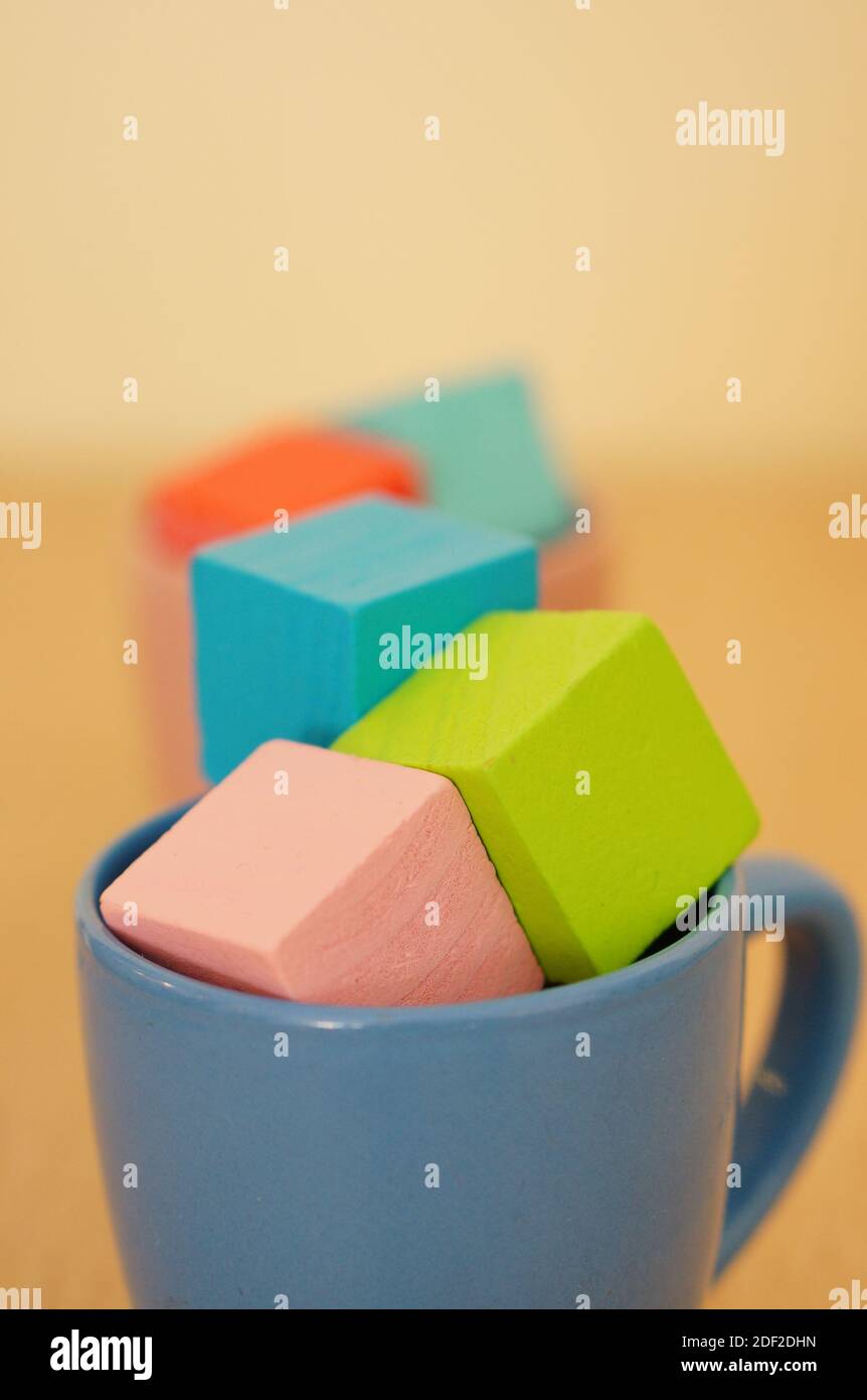 A vertical shot of colorful wooden square toys in the cups Stock Photo ...