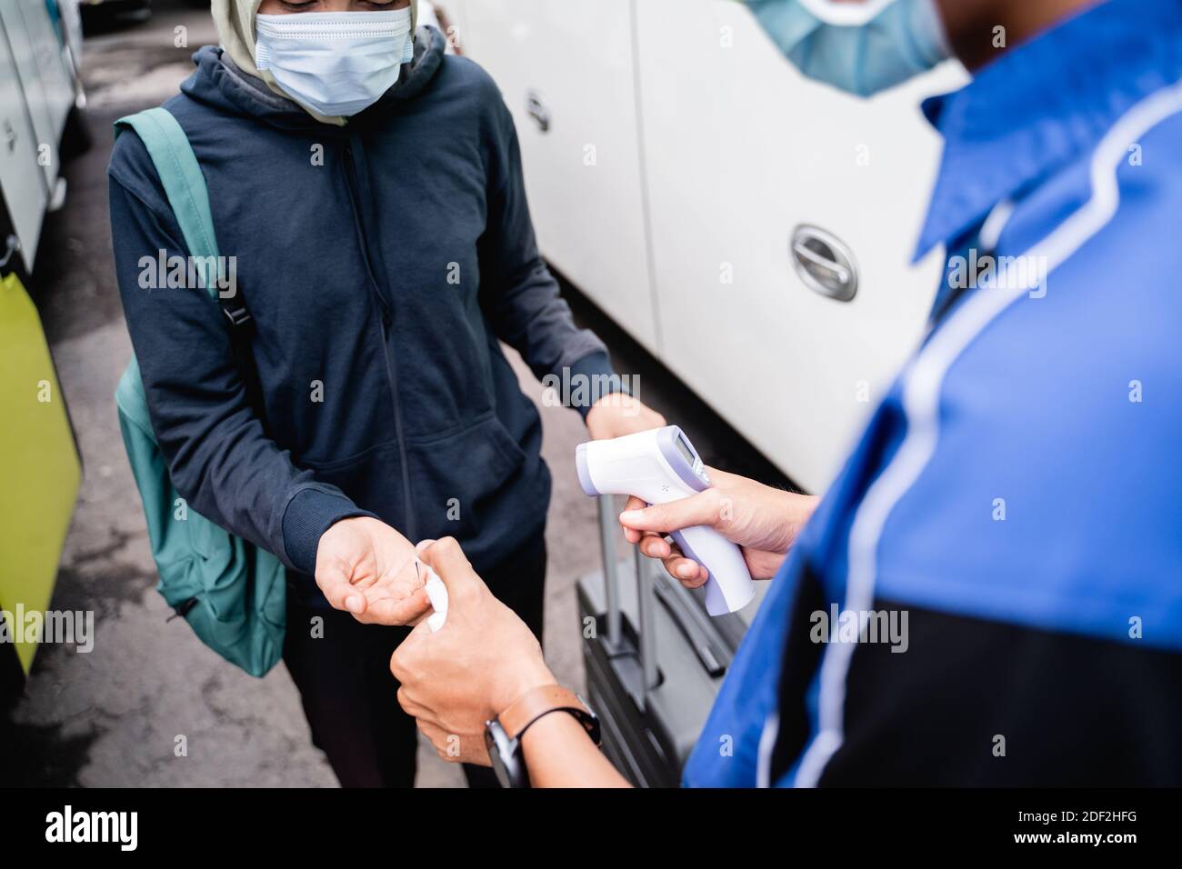 asian passenger temprature check and hand sanitize before riding a bus ...