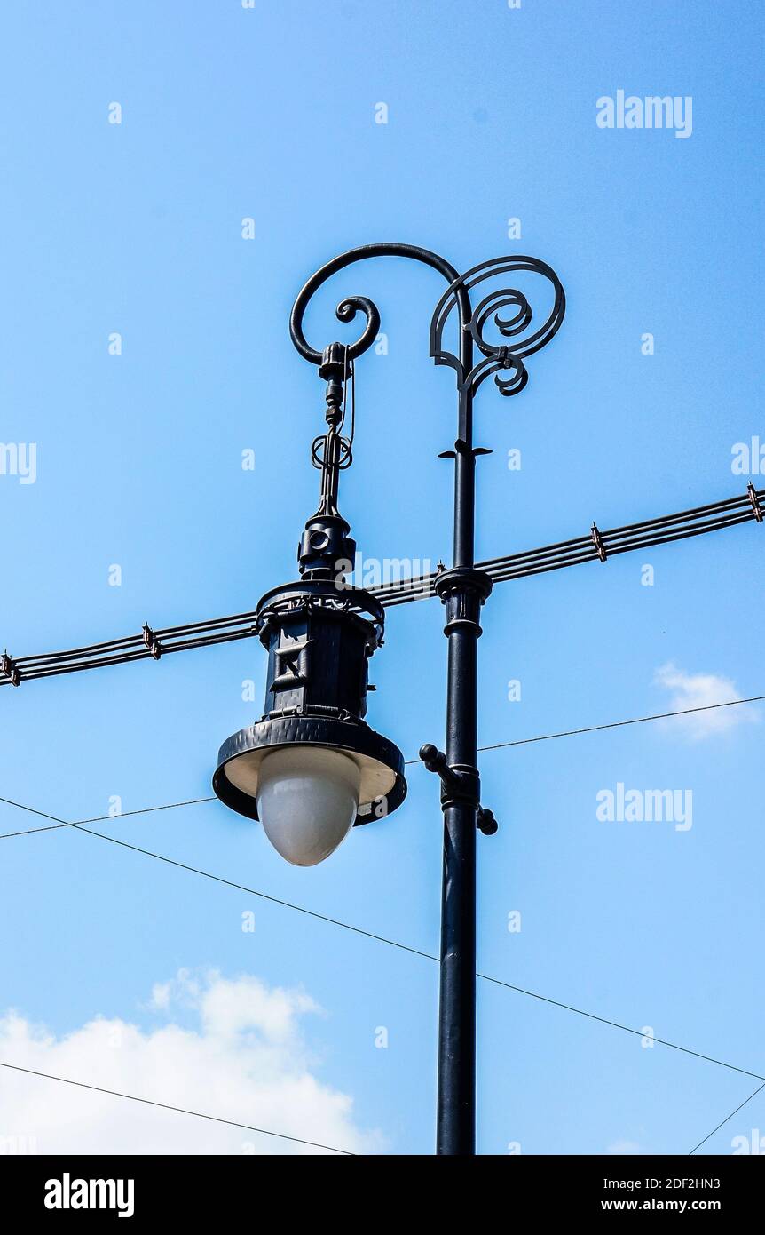A vertical shot of an electric street lamp with the sky in the ...