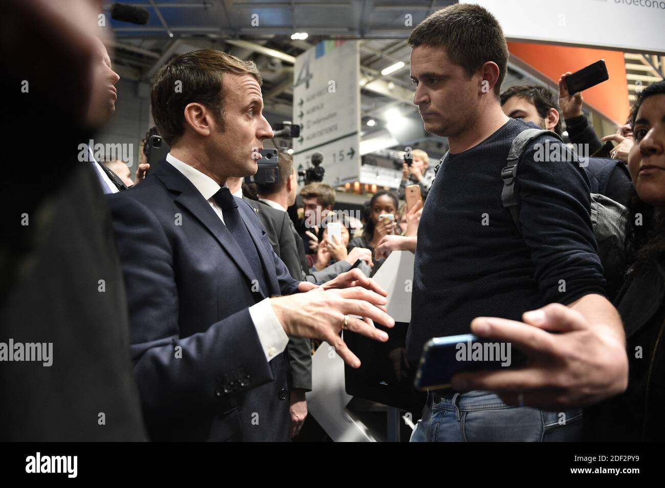 French President Emmanuel Macron speaks with a fair attendee as he ...