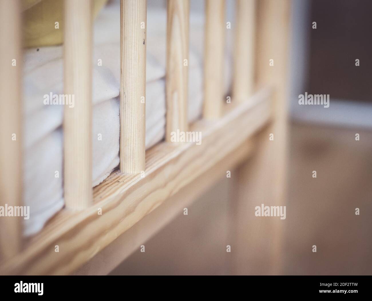 The side part of a baby's cradle with bedsheets inside it Stock Photo ...