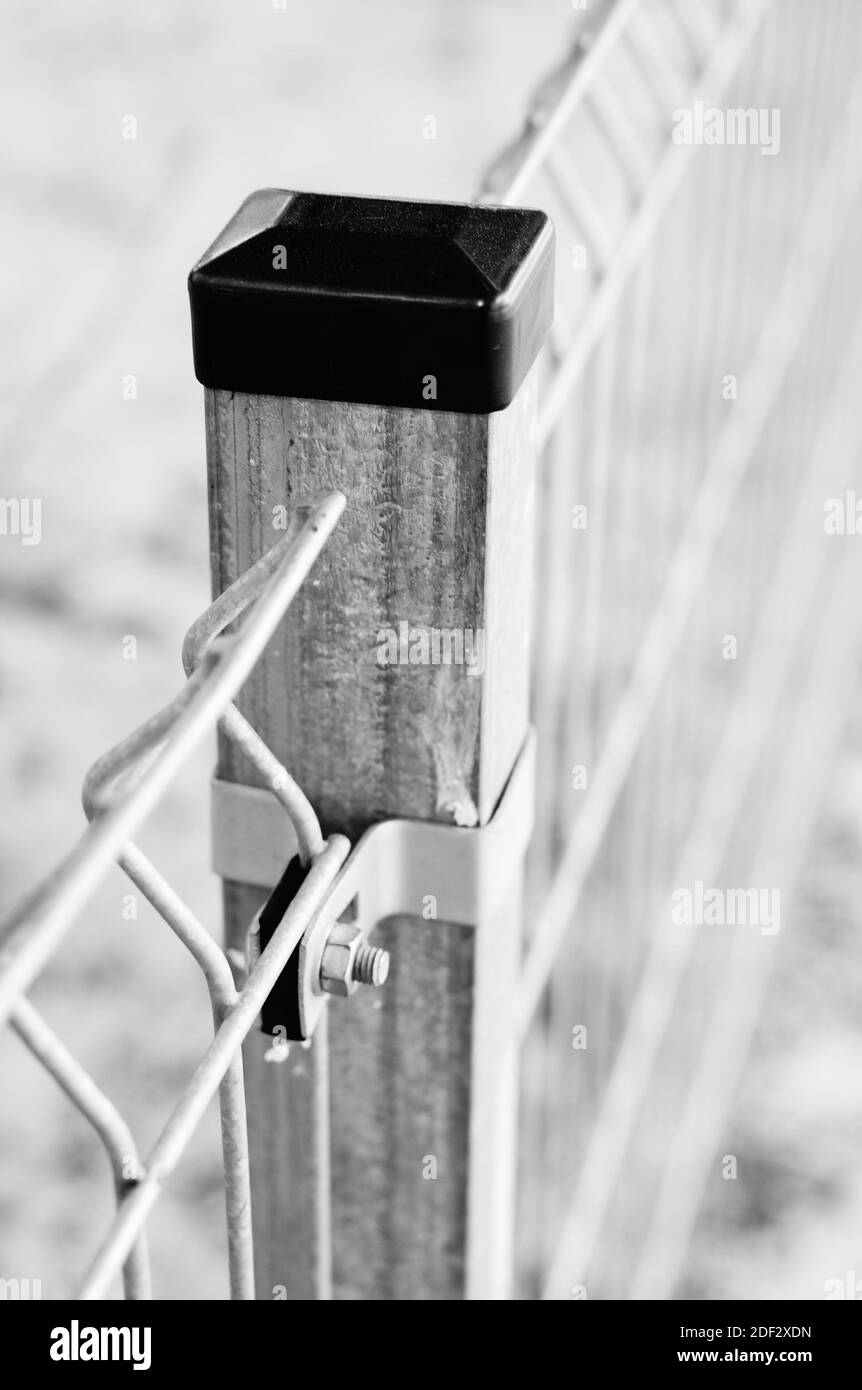 A vertical greyscale closeup shot of a metal grid fence pole Stock ...