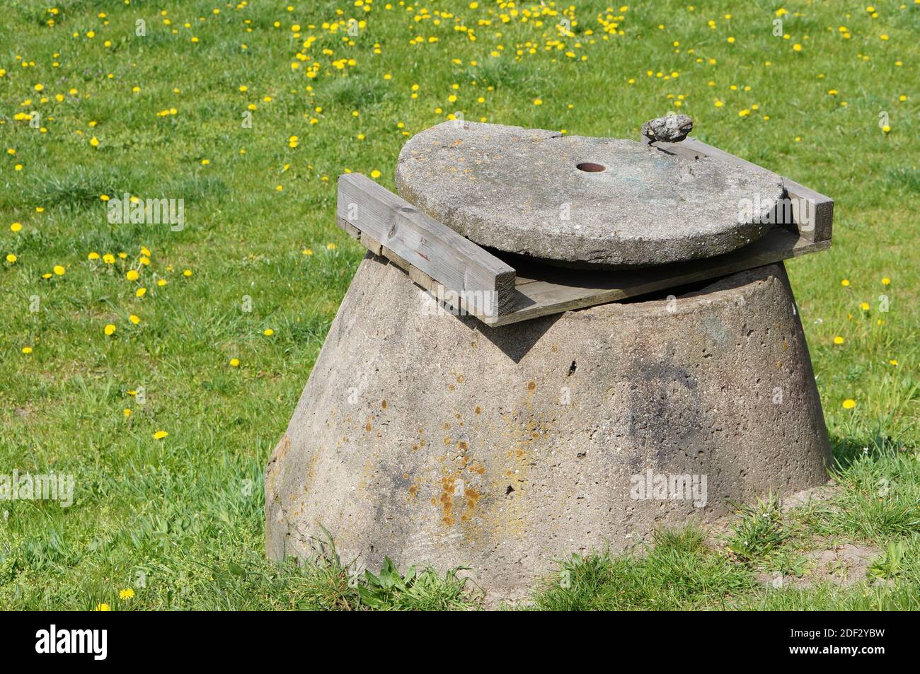 Stone sewer with cover on green grass Stock Photo - Alamy