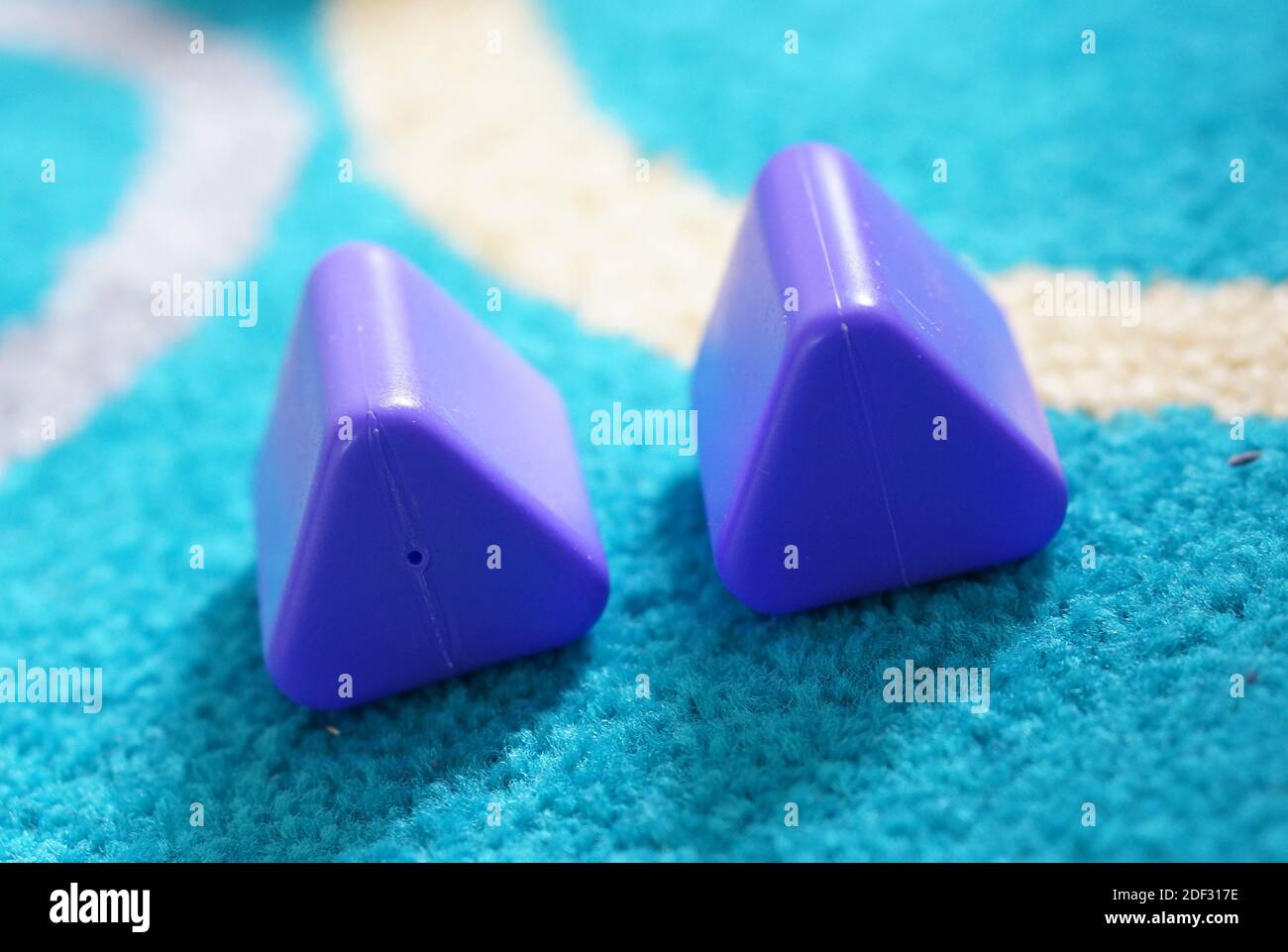 A closeup shot of blue plastic toy triangles on a carpet Stock Photo ...