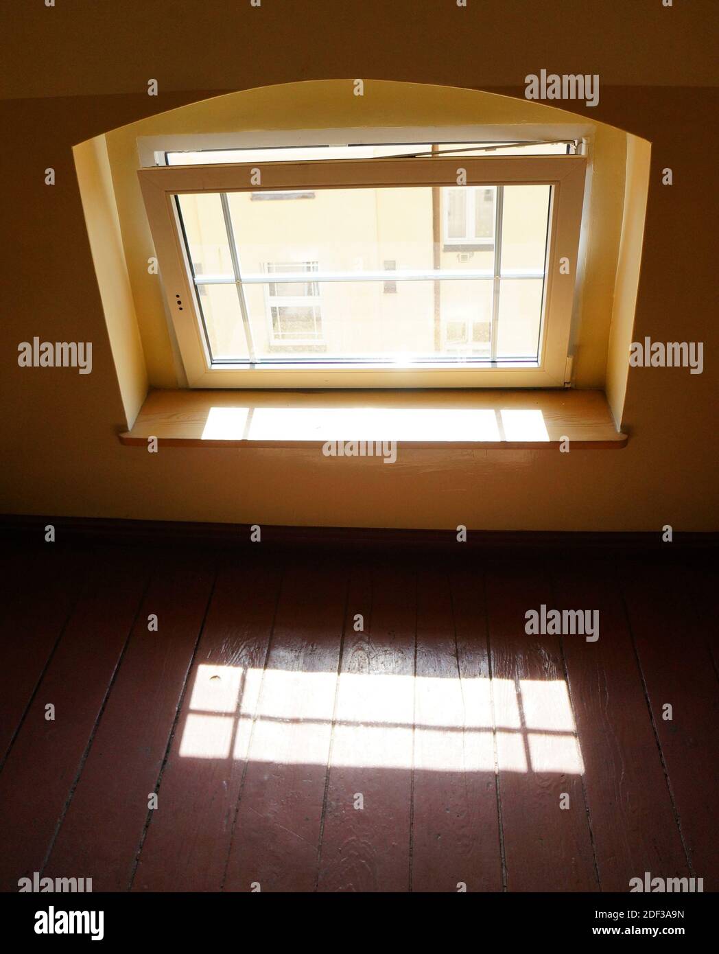 A light coming from the window creating a shadow on the wooden floor ...