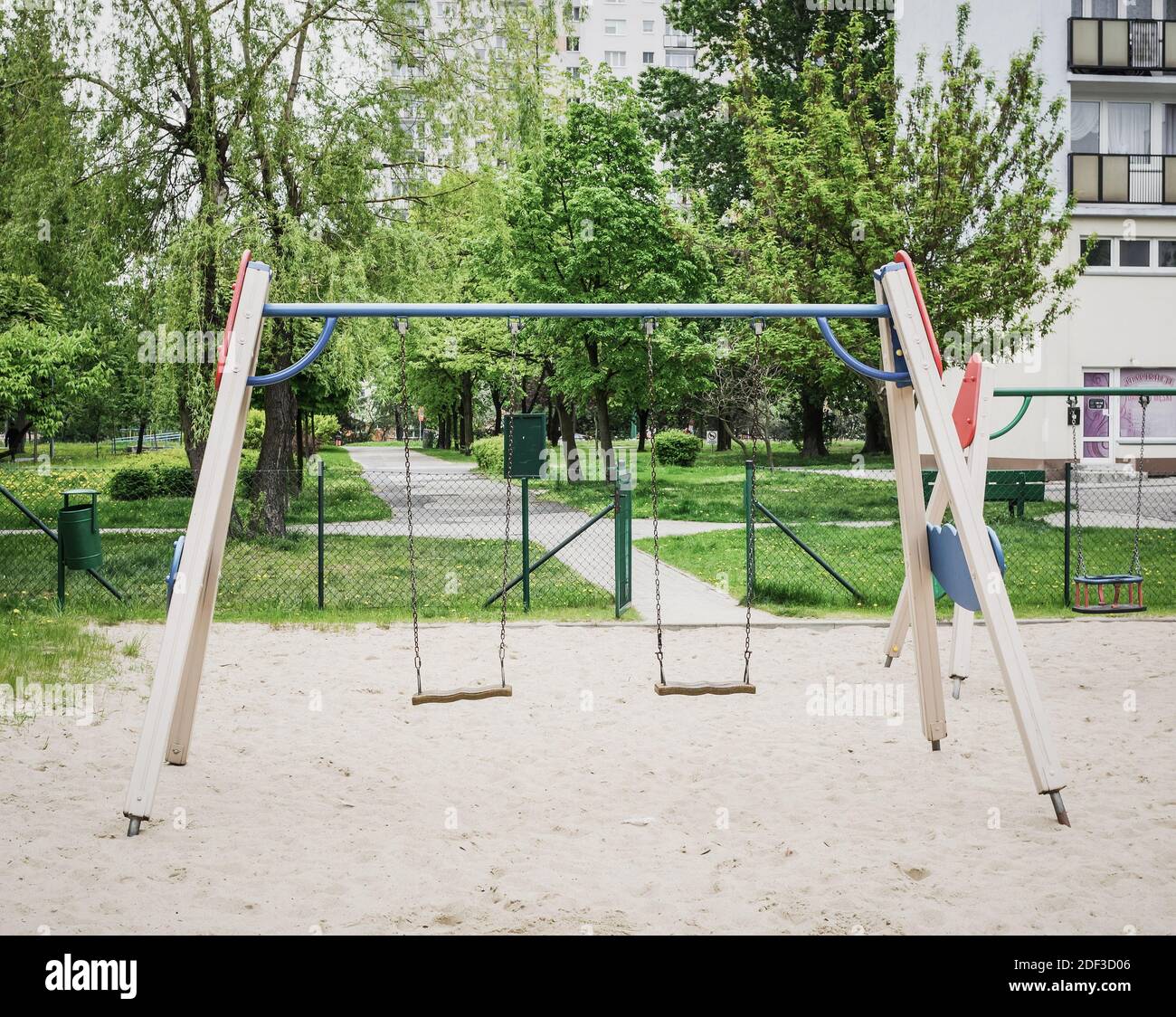 A wooden swing set on a playground during daytime Stock Photo - Alamy