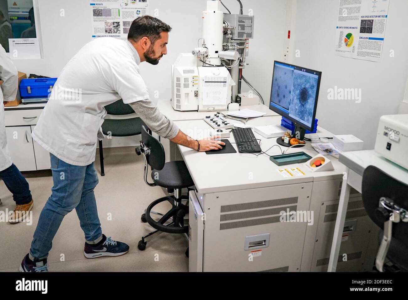 Biologist analyzing the Coronavirus virus under a digital microscope ...