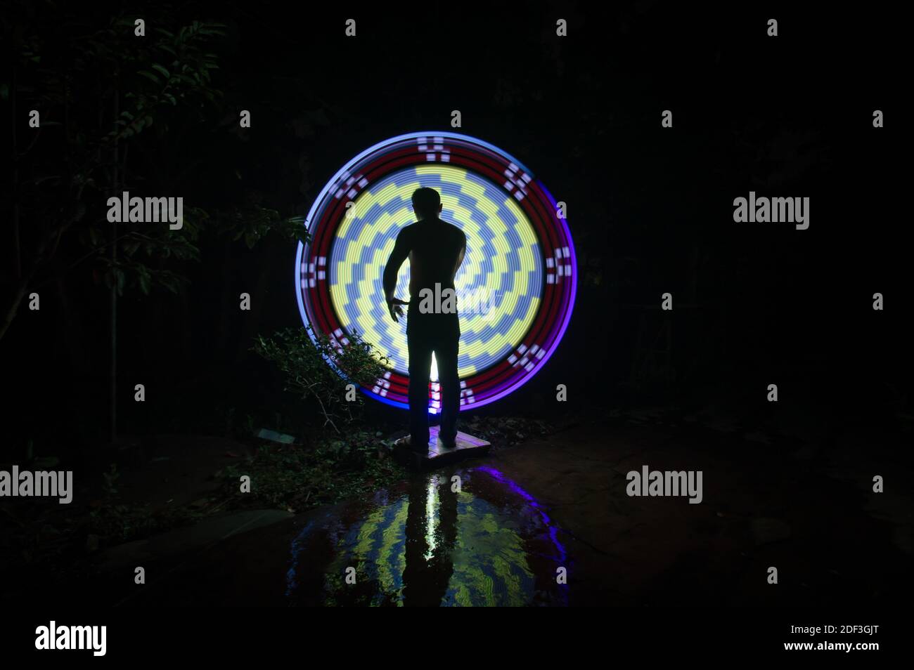 One person standing alone against beautiful color circle LED light ...