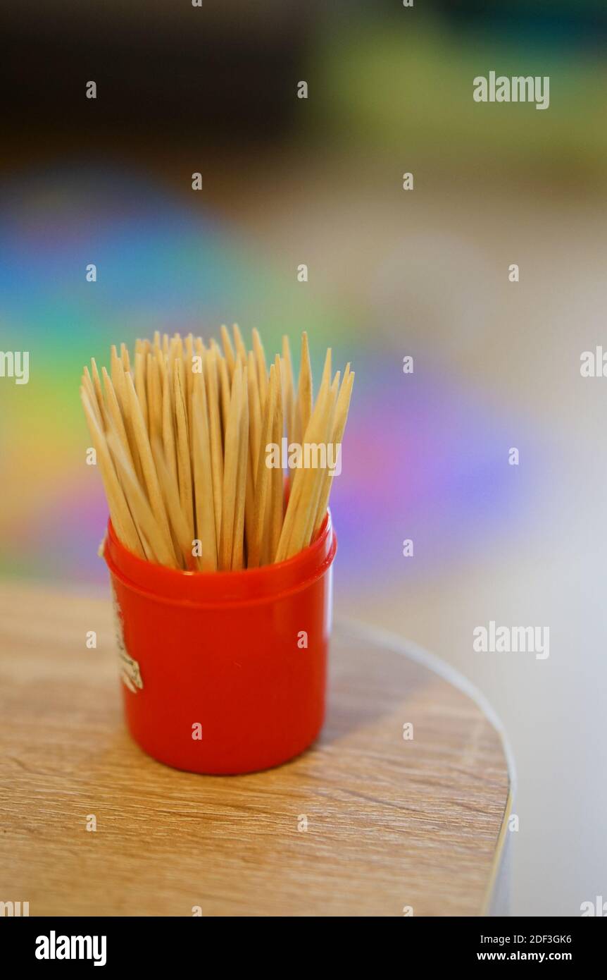 A vertical closeup shot of toothpicks in a red plastic cup with a ...