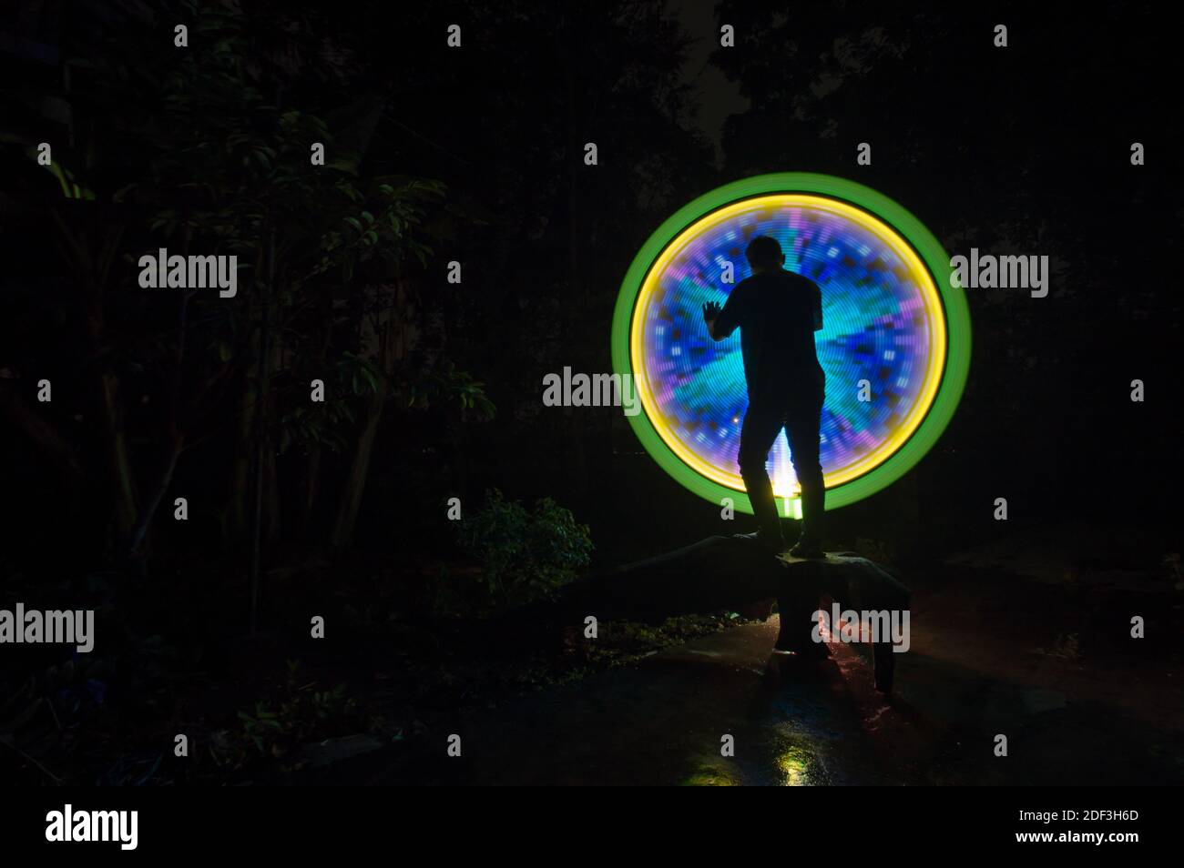 One person standing alone against beautiful color circle LED light ...