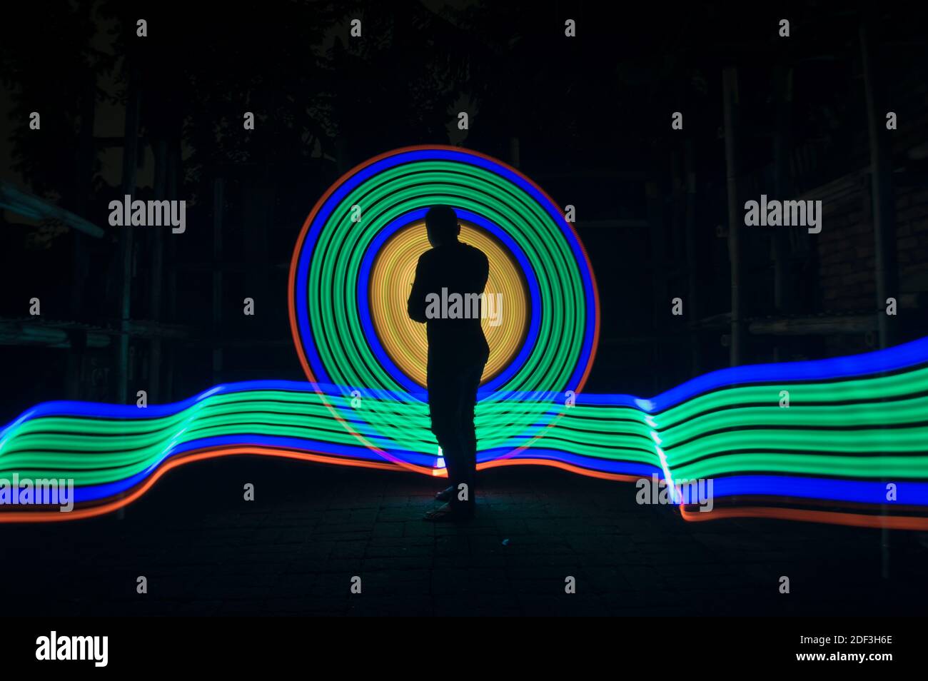 One person standing alone against beautiful color circle LED light ...