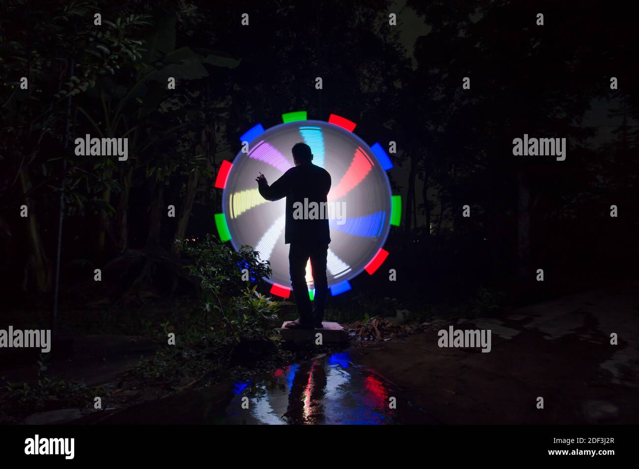 One person standing alone against beautiful color circle LED light ...