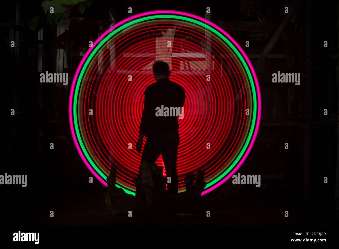 One person standing alone against beautiful color circle LED light ...