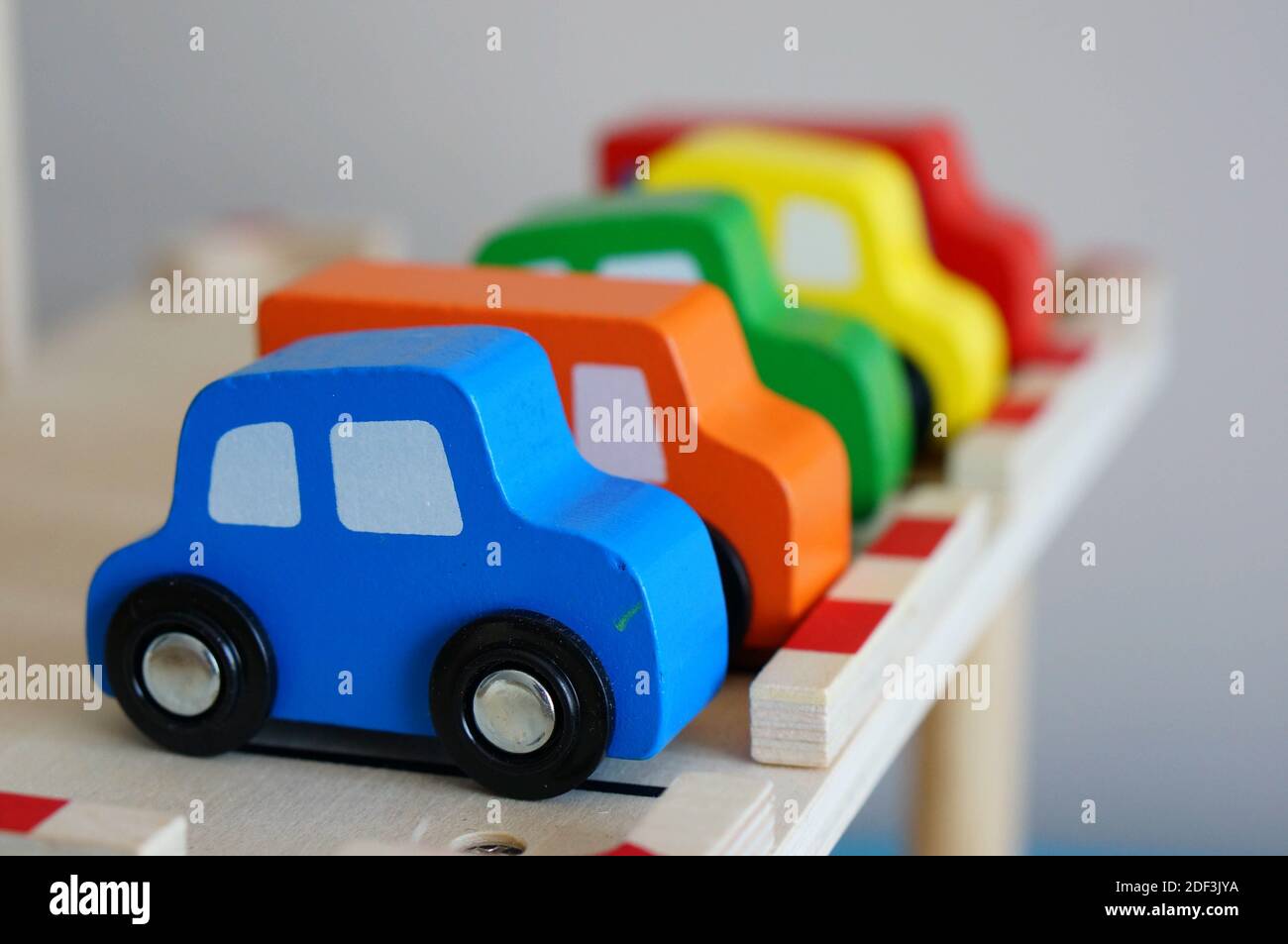 A closeup of colorful wooden car toys on a wooden table under the ...
