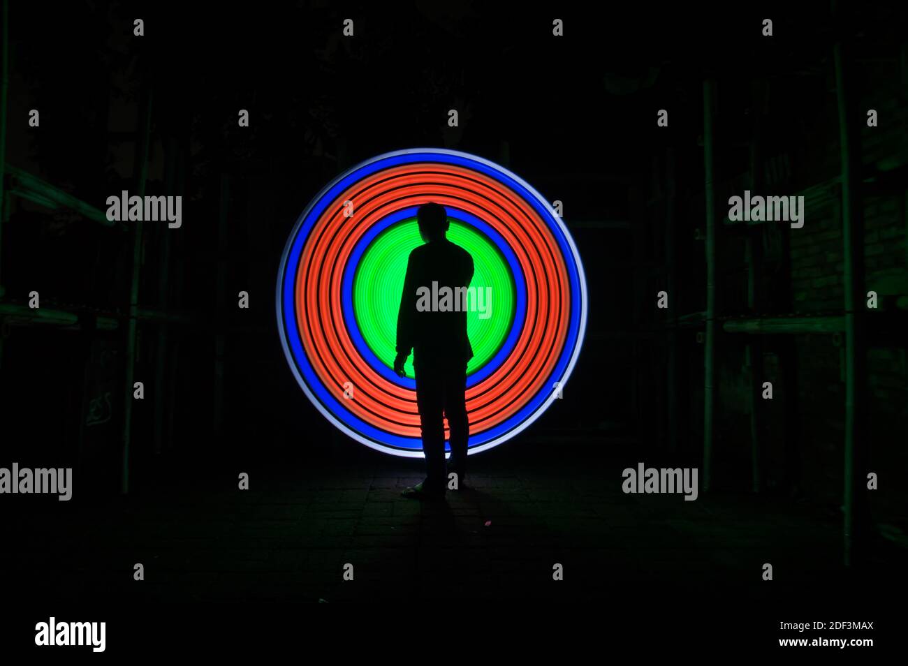 One person standing alone against beautiful color circle LED light ...