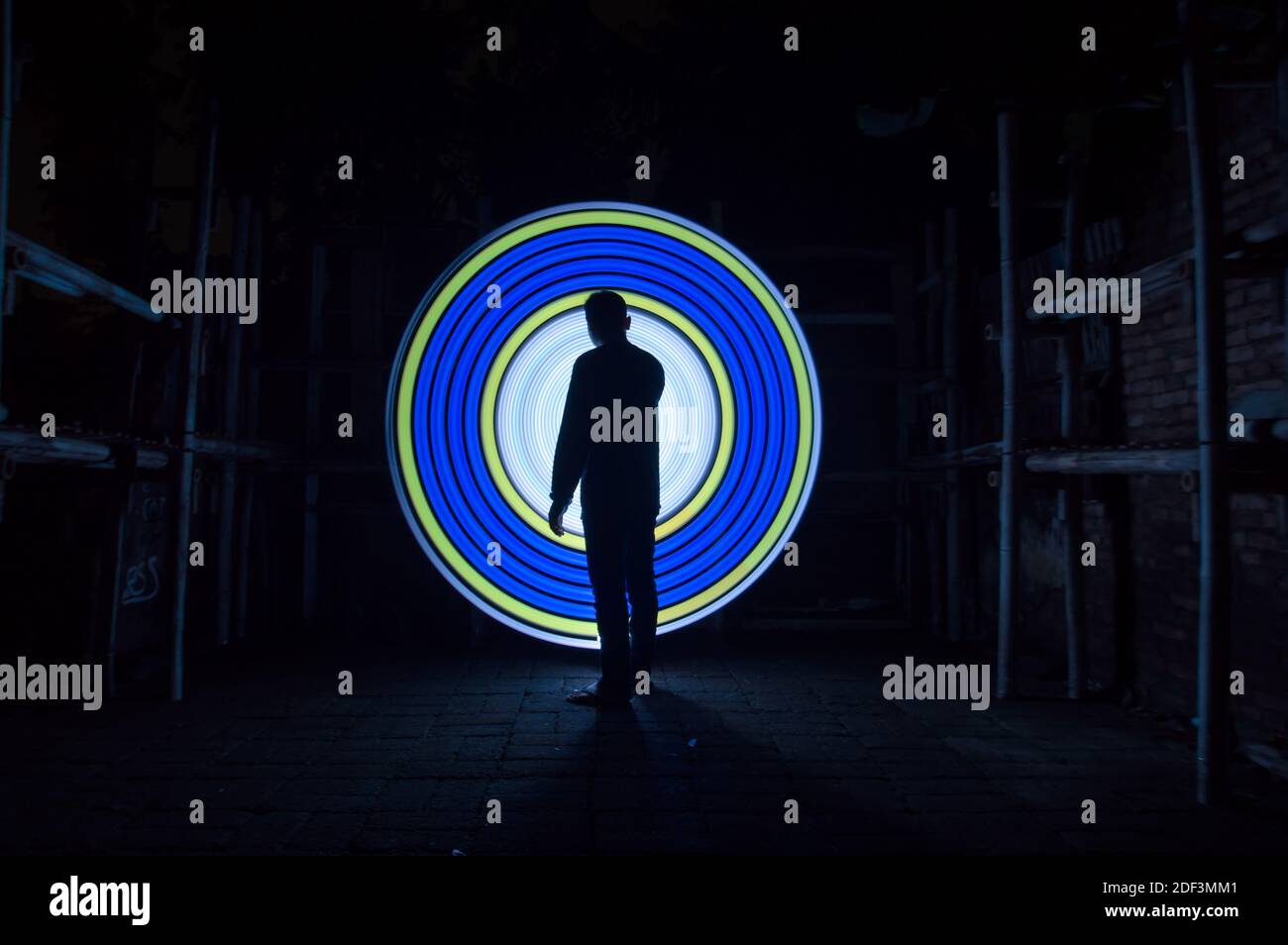 One person standing alone against beautiful color circle LED light ...