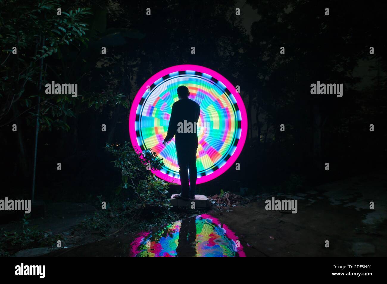 One person standing alone against beautiful color circle LED light ...