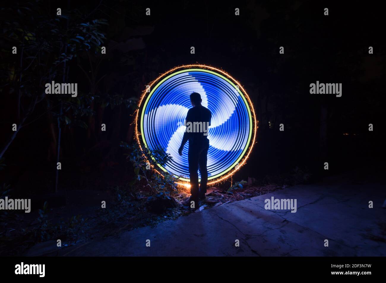 One person standing alone against beautiful color circle LED light ...