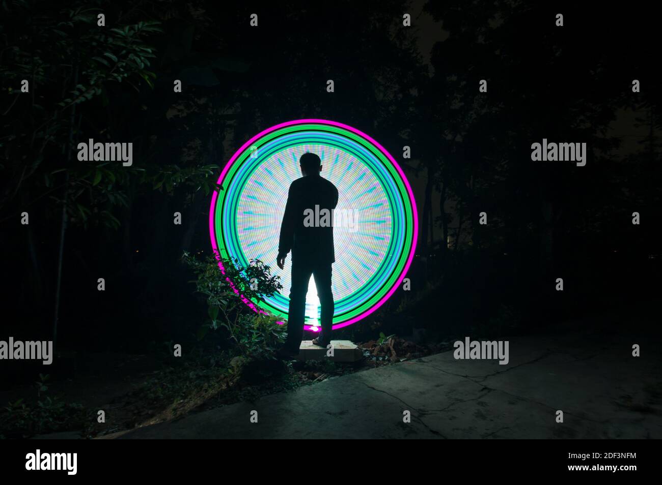 One person standing alone against beautiful color circle LED light ...