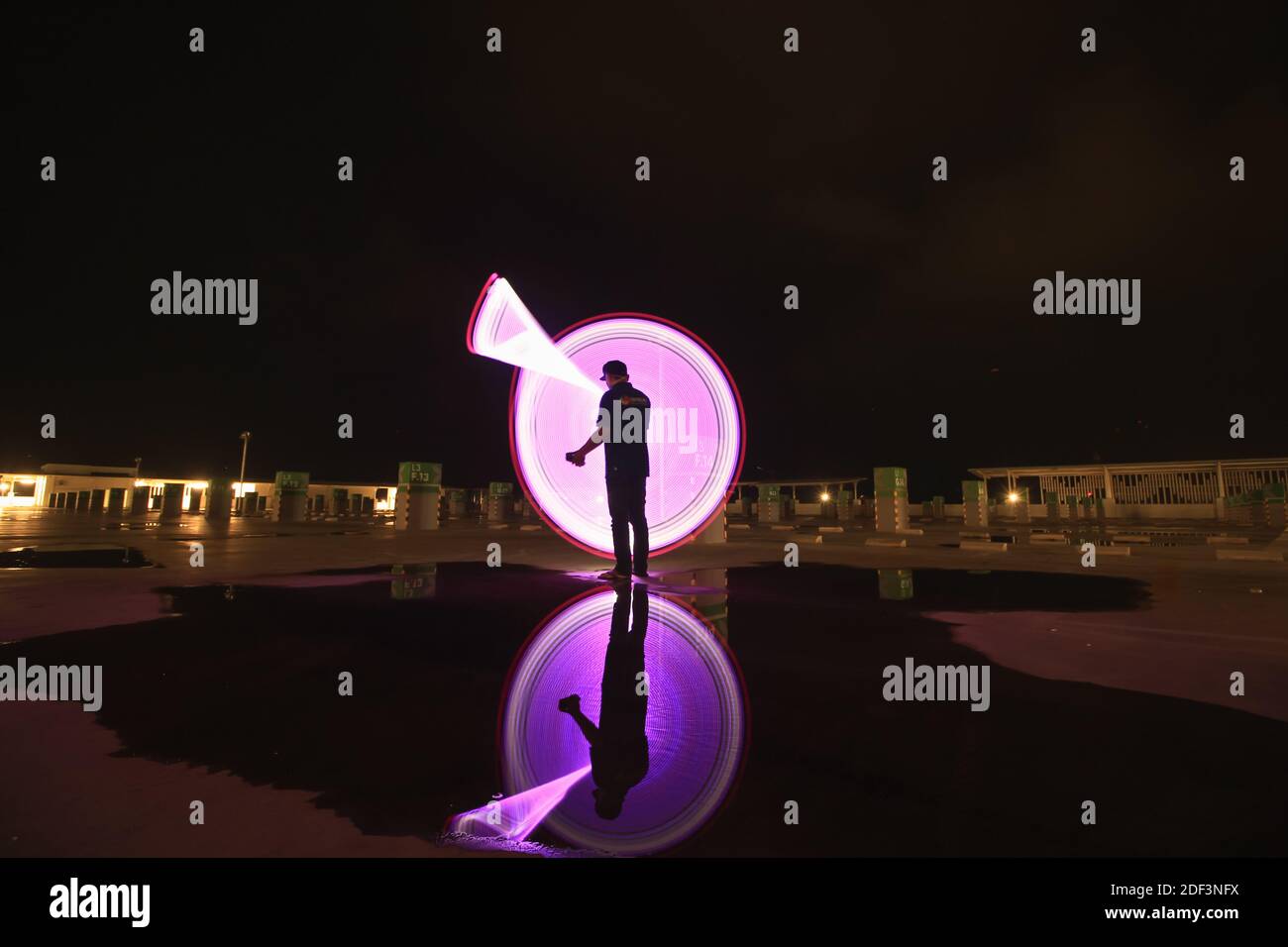 One person standing alone against beautiful color circle LED light ...