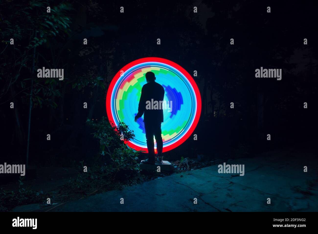 One person standing alone against beautiful color circle LED light ...