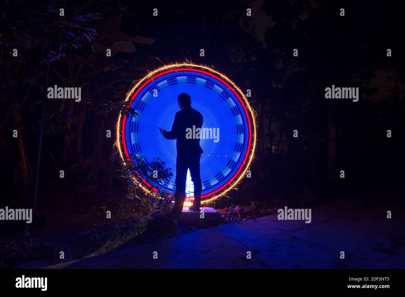 One person standing alone against beautiful color circle LED light ...