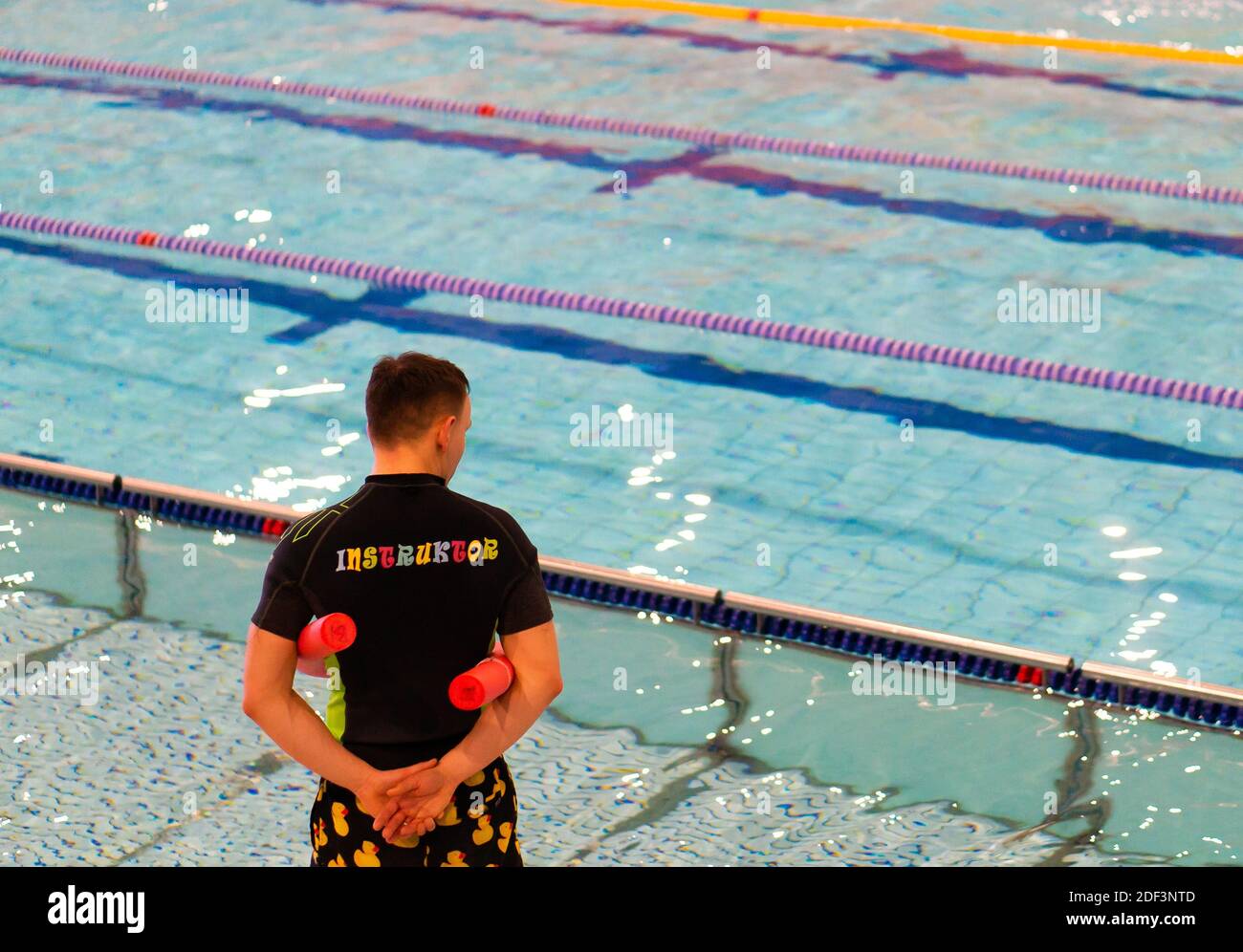 POZNAN, POLAND - Dec 02, 2019: Swim teacher standing next to a swimming ...