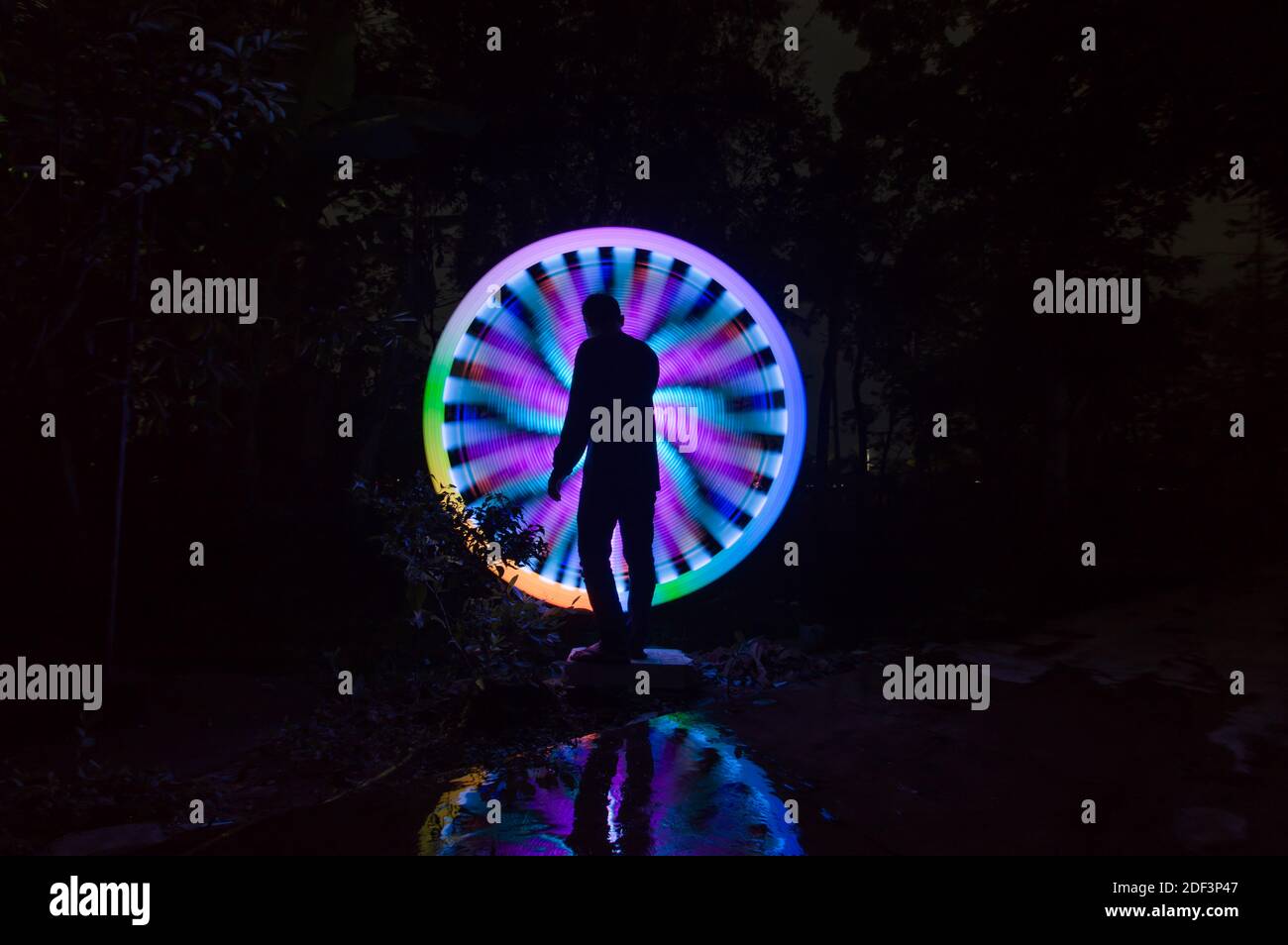 One person standing alone against beautiful color circle LED light ...