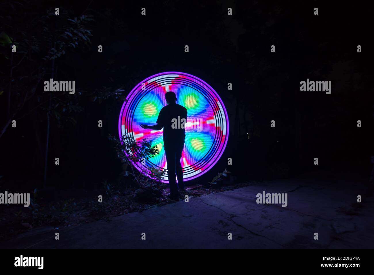 One person standing alone against beautiful color circle LED light ...