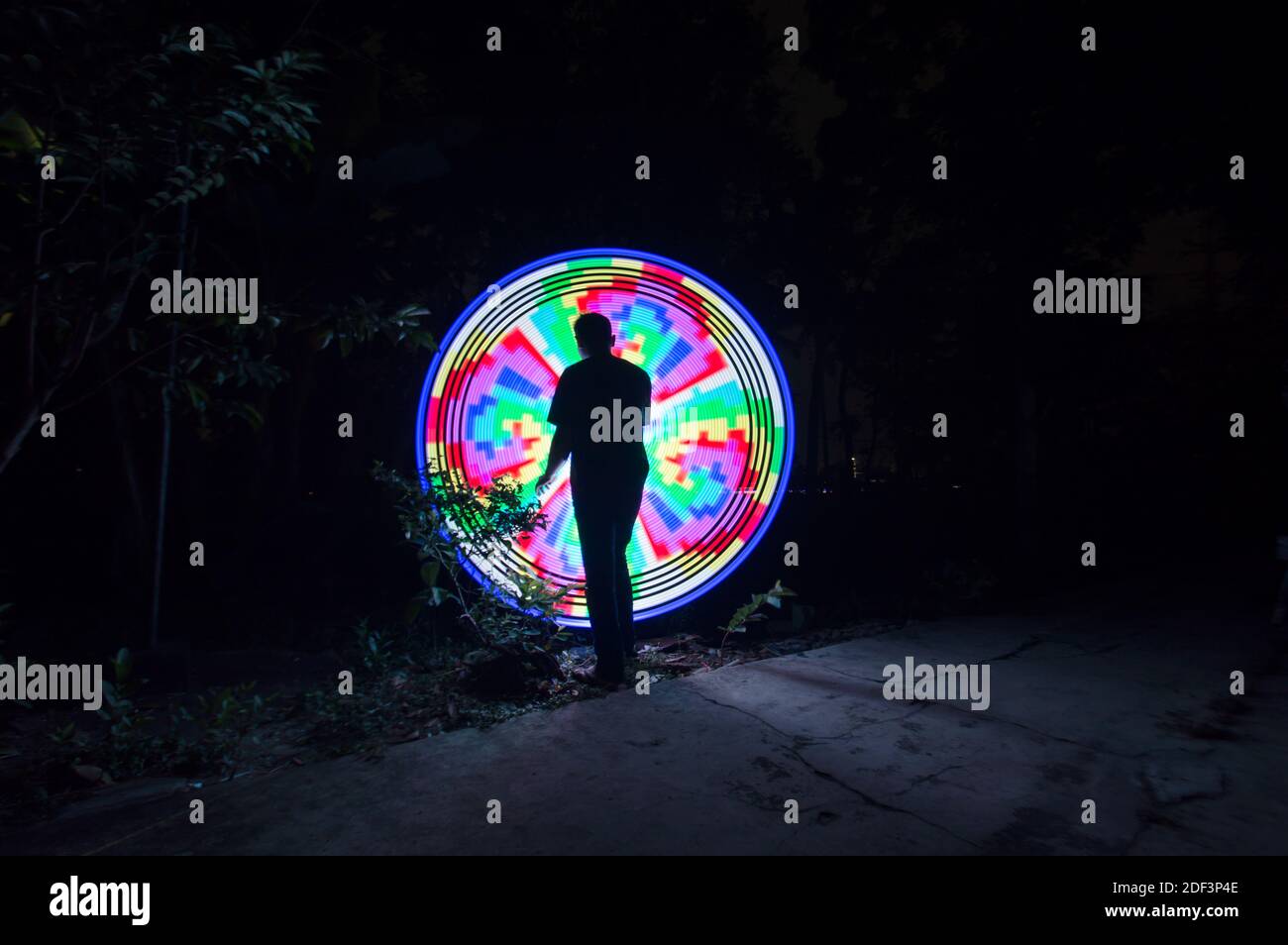 One person standing alone against beautiful color circle LED light ...