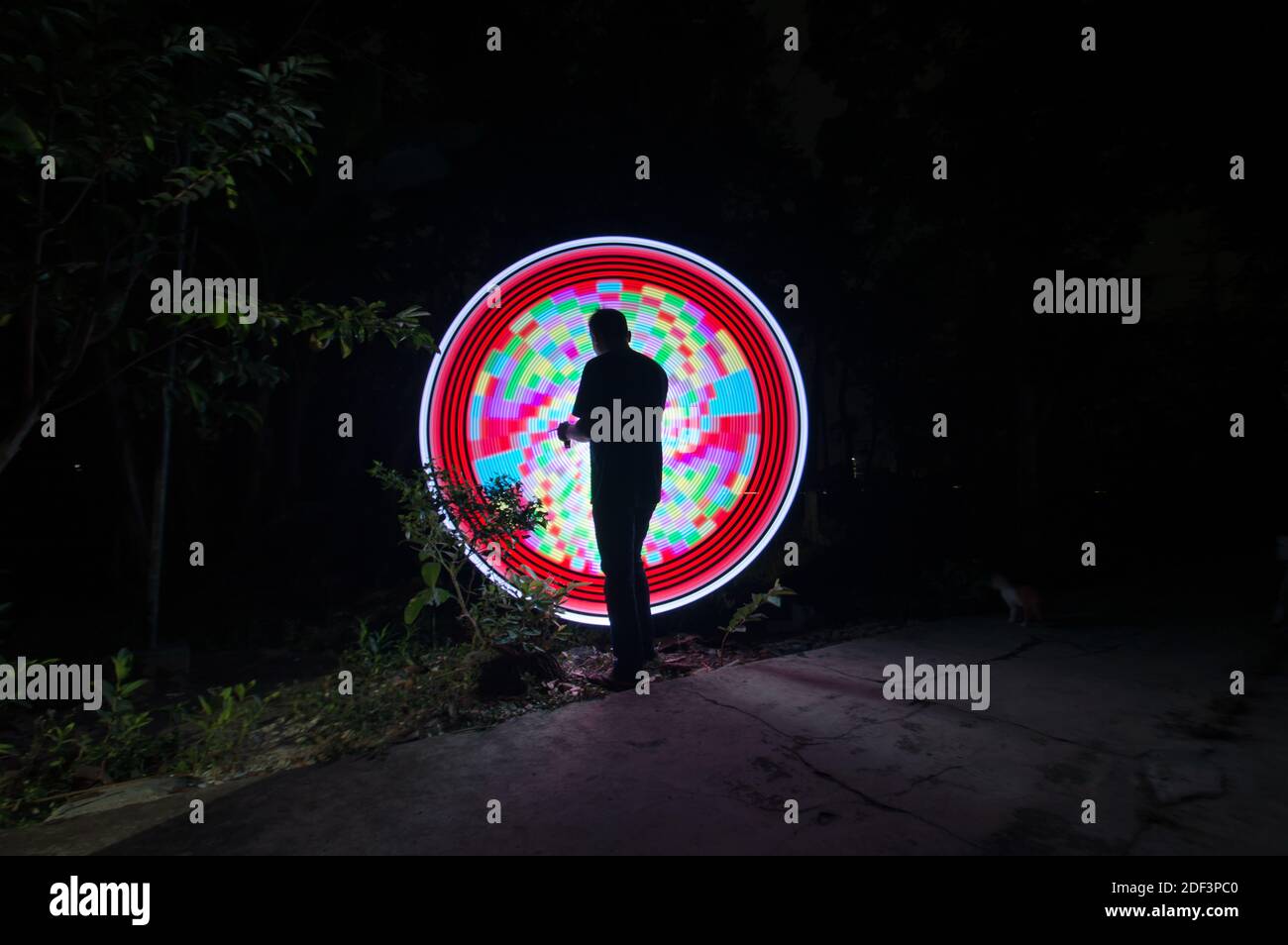 One person standing alone against beautiful color circle LED light ...
