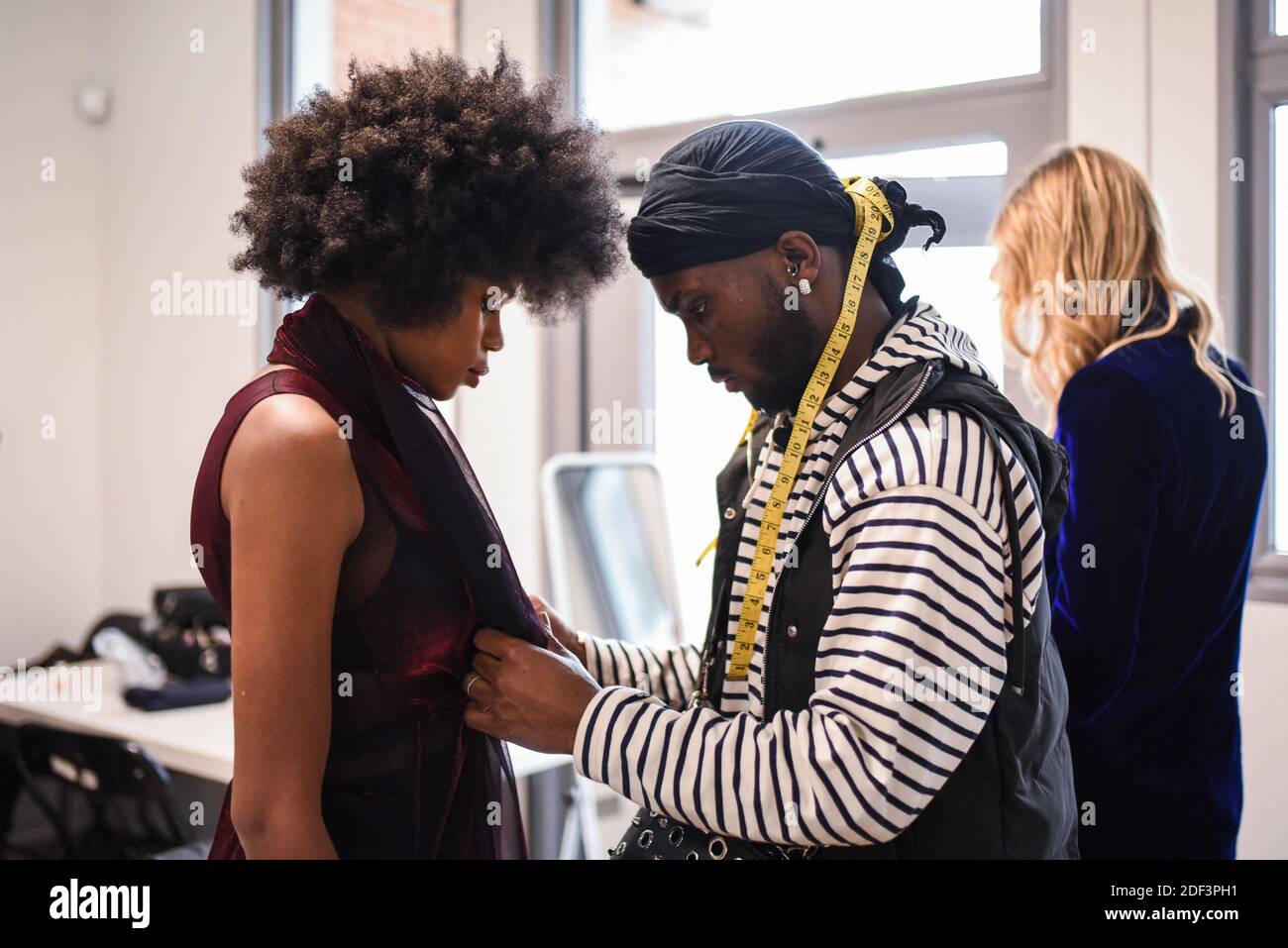 Roby dresses a model before the Kipre couture Fall Winter 2020 show on ...