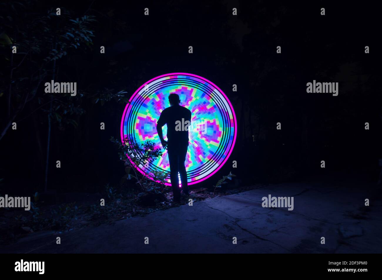 One person standing alone against beautiful color circle LED light ...