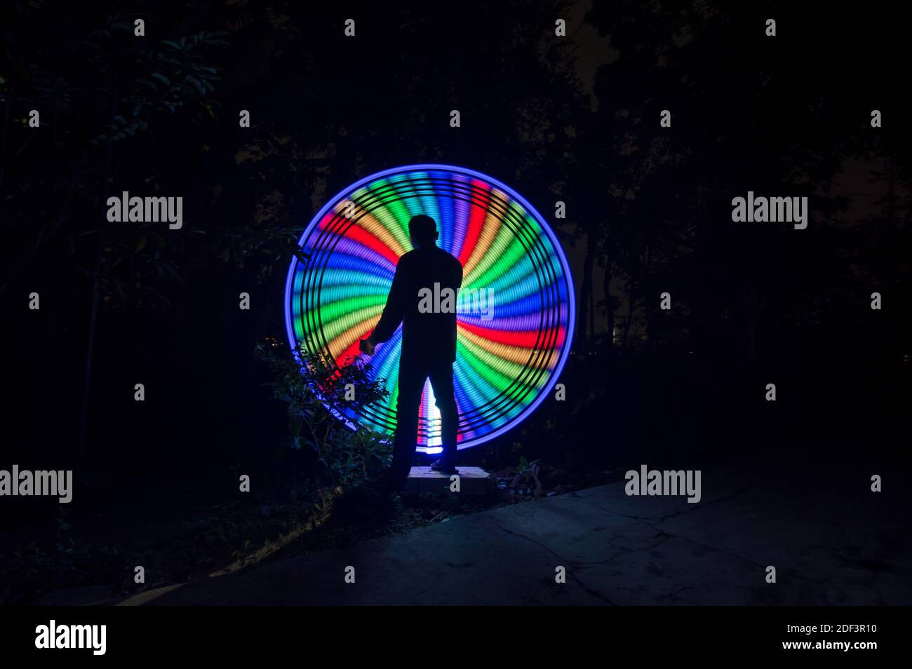One person standing alone against beautiful color circle LED light ...