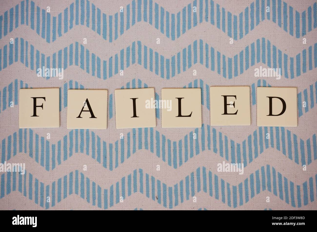 The word failed written by letters on small squares on a blue and white ...