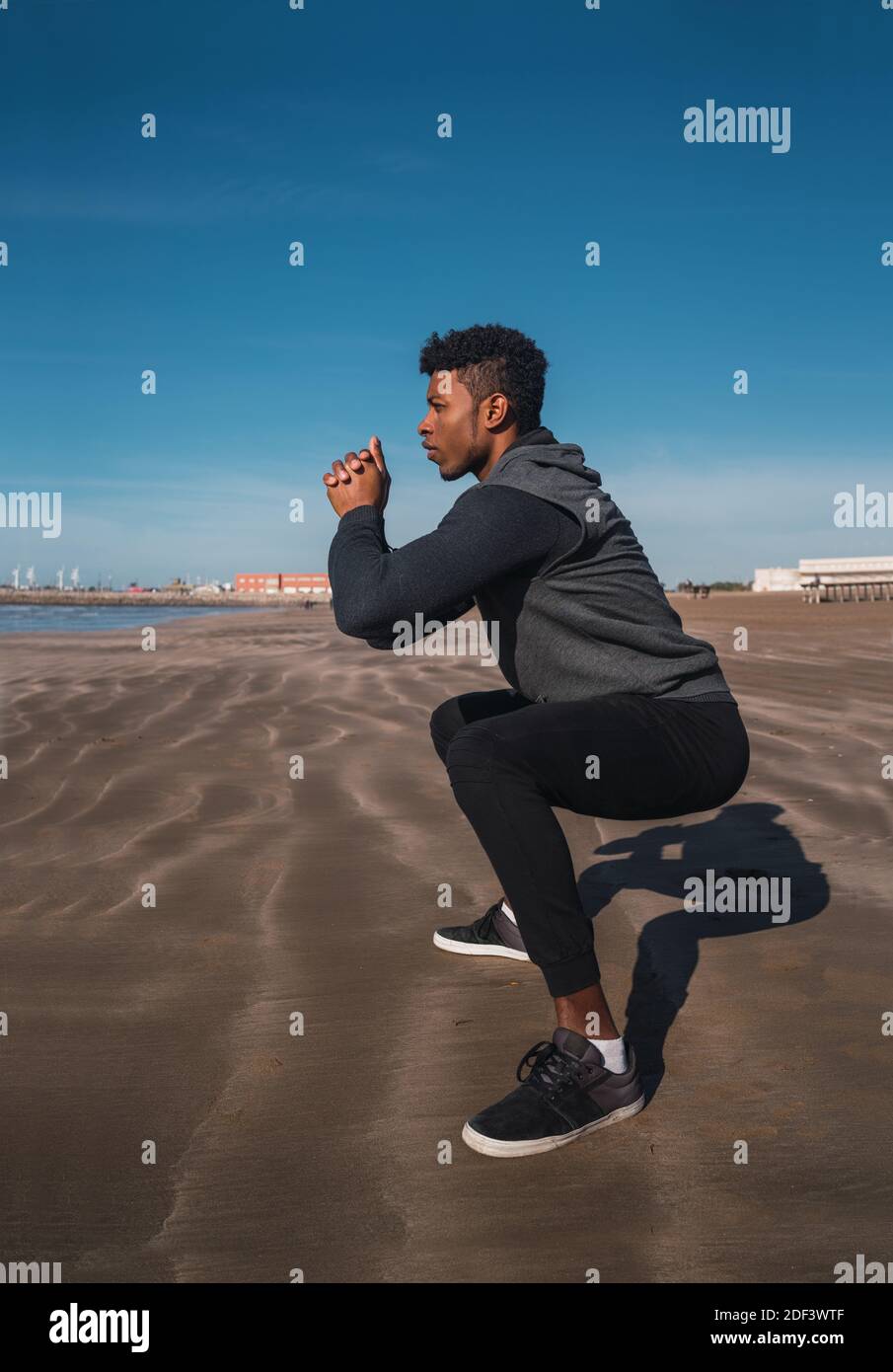 Athletic man doing exercise at the beach Stock Photo - Alamy