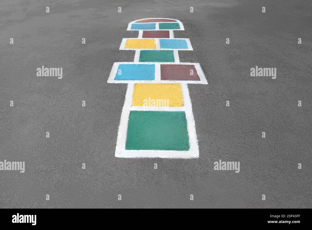 Hopscotch game being drawn with a colorful paint on the asphalt ground ...