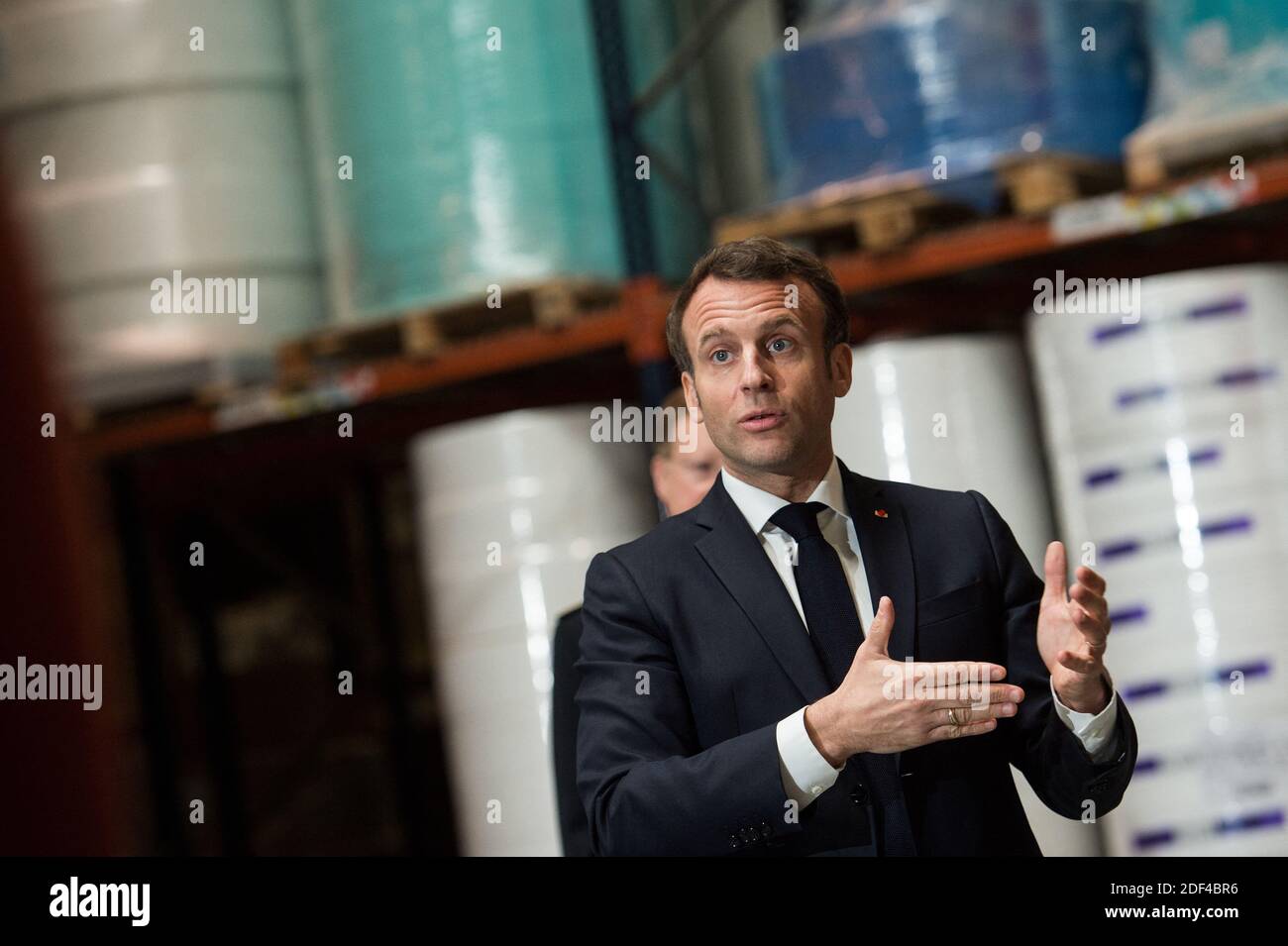 French President Emmanuel Macron talks to employees as he visits the ...