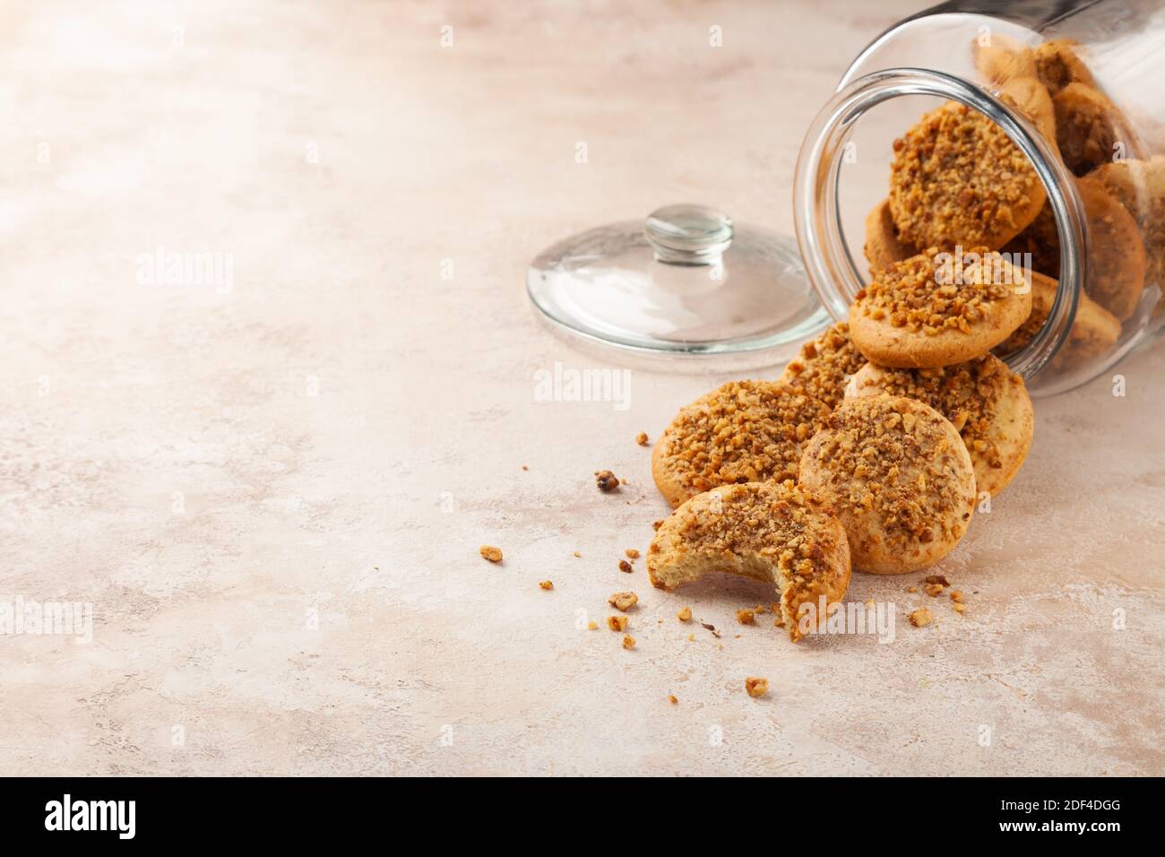 Sweet round cookies with nuts, scattered from transparent glass bank ...