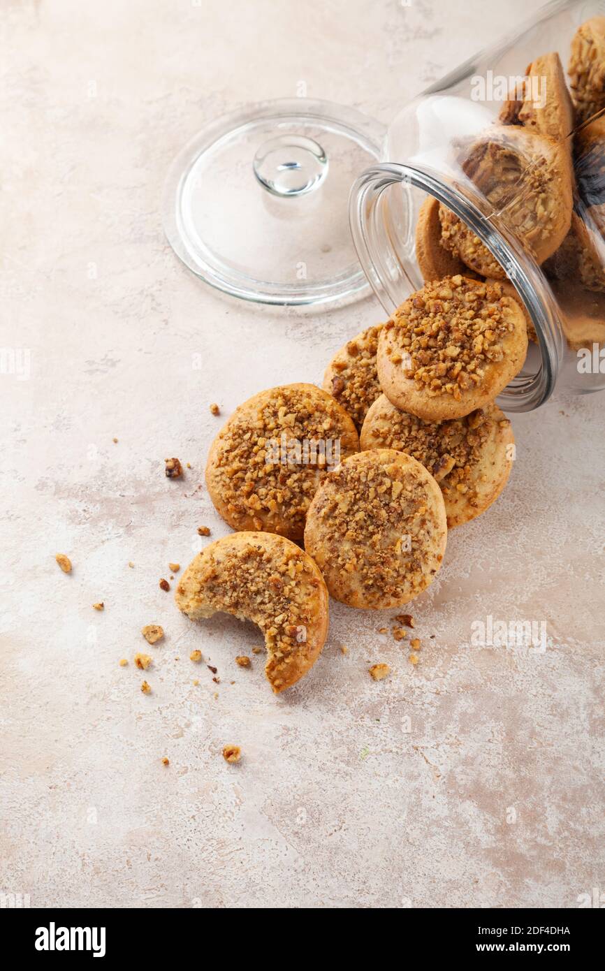 Sweet round cookies with nuts, scattered from transparent glass bank ...