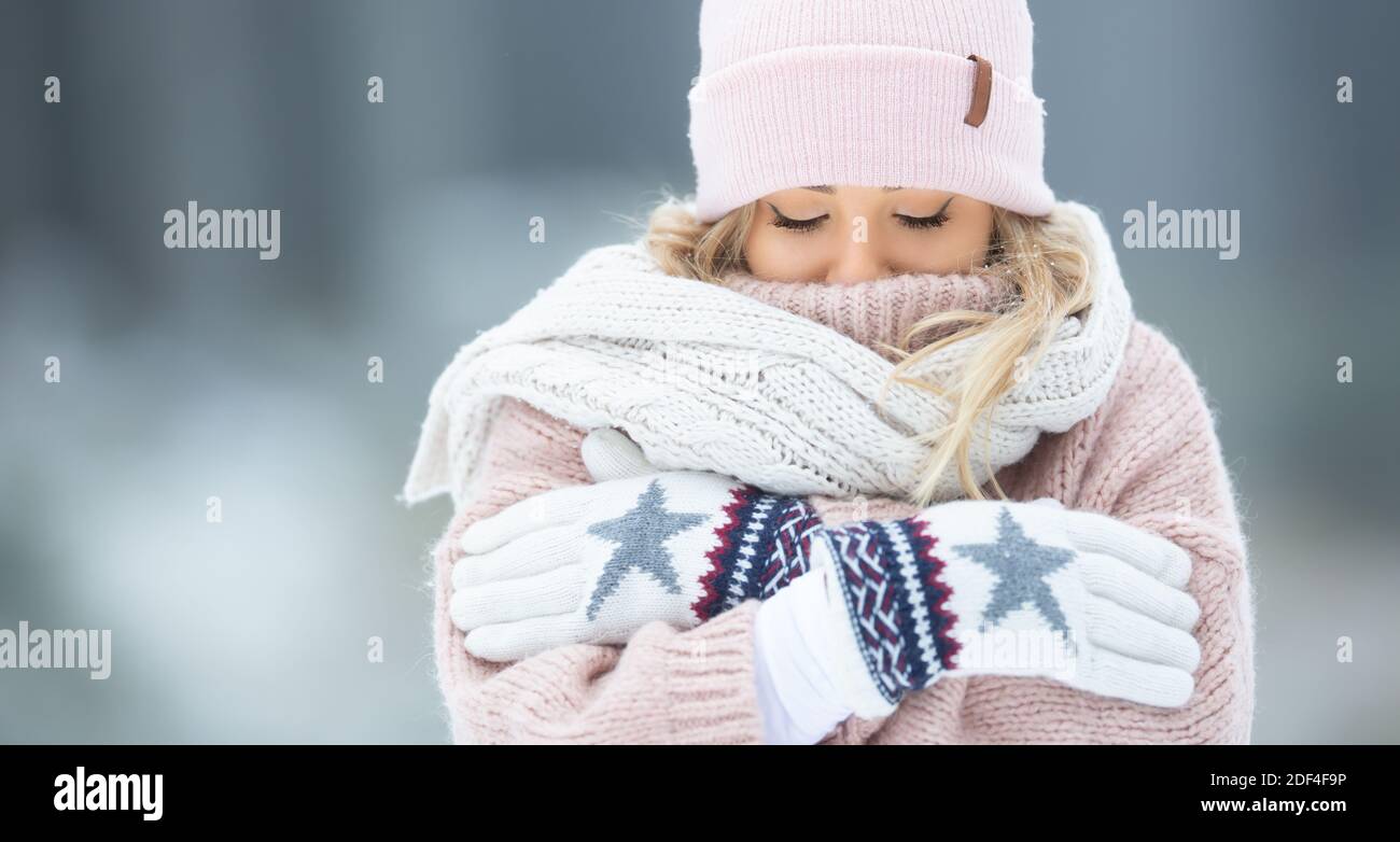 Freezing cold woman dressed in wooly clothes on a winter day, covered ...