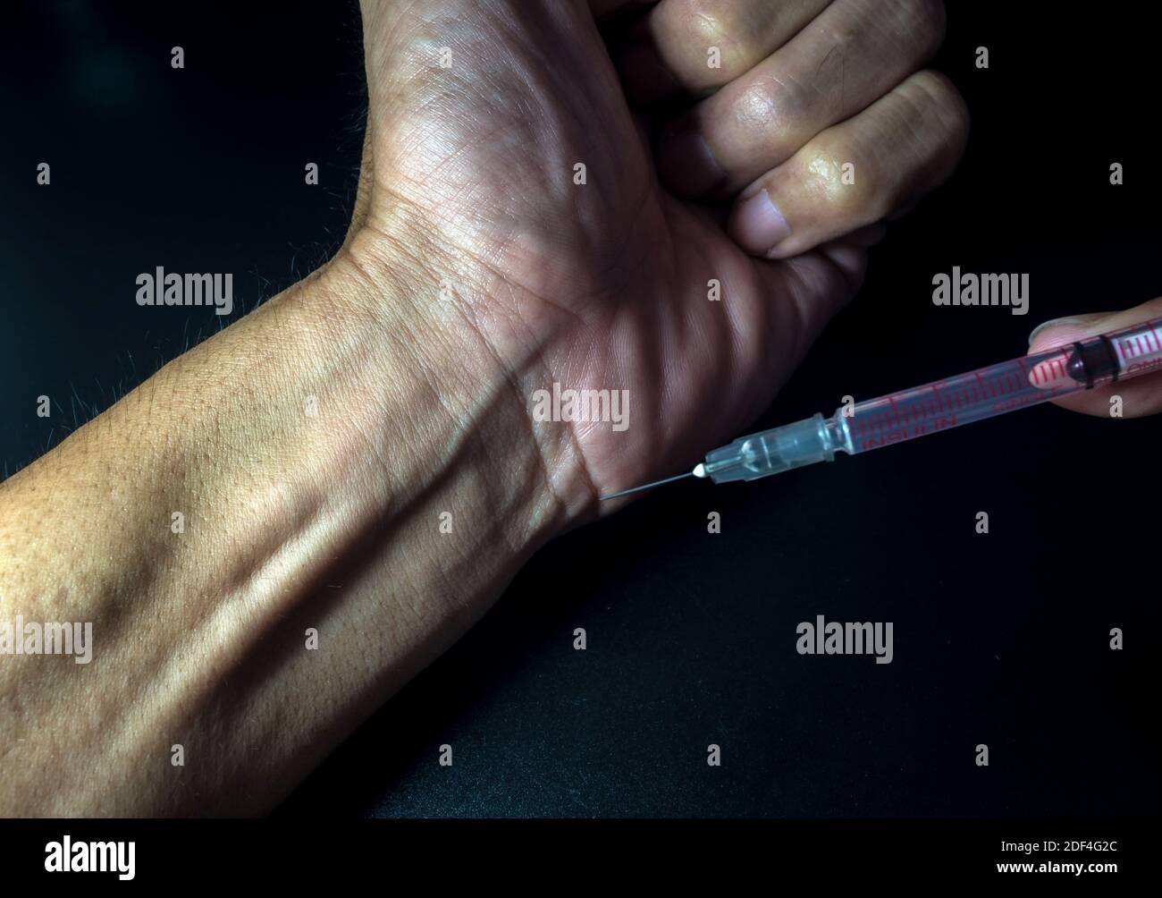 Man injecting with a syringe to his hand Stock Photo - Alamy
