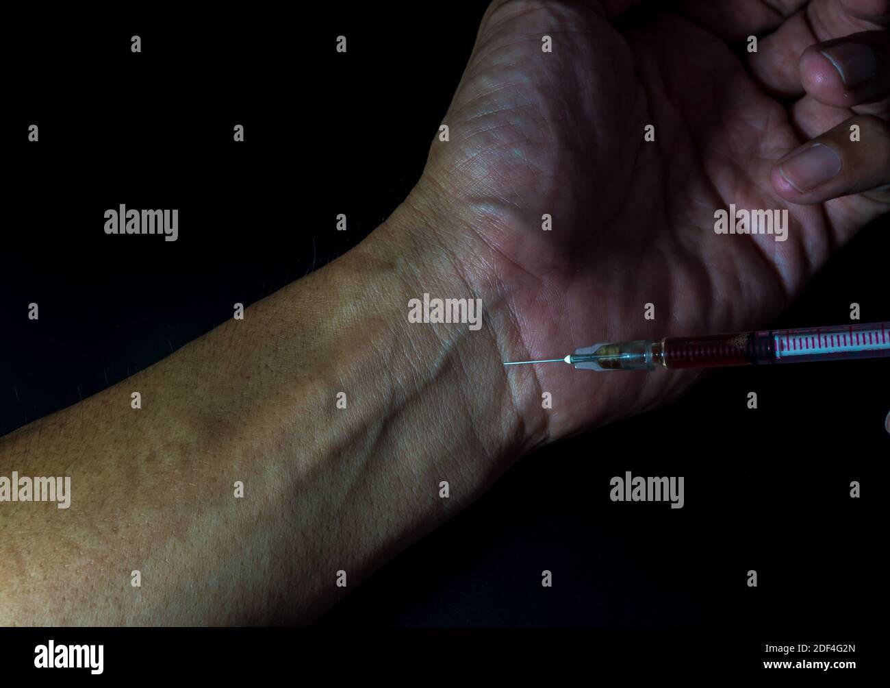 Man injecting with a syringe to his hand Stock Photo - Alamy