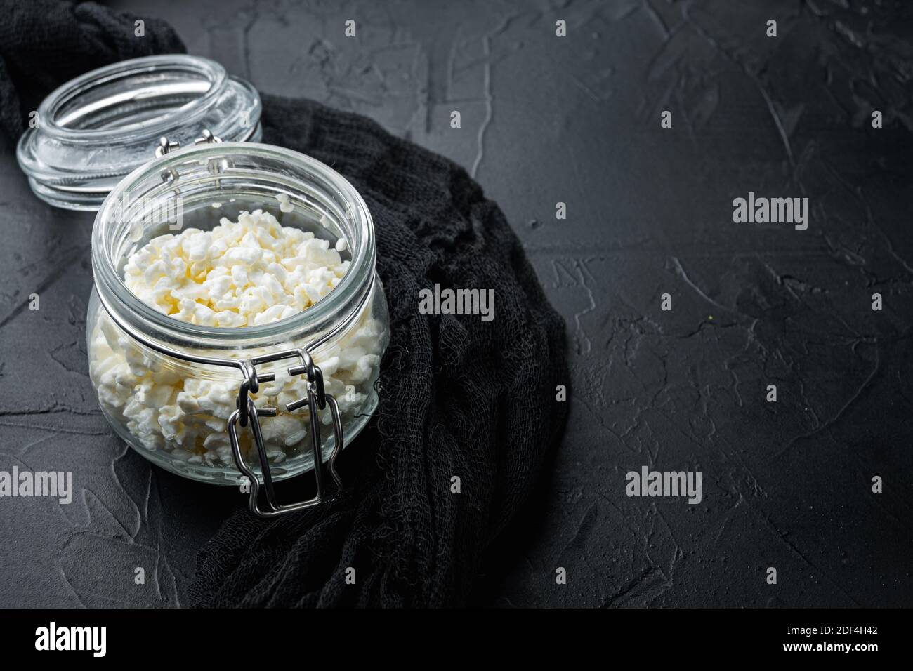 Cottage cheese, curd, on black textured background with space for text ...