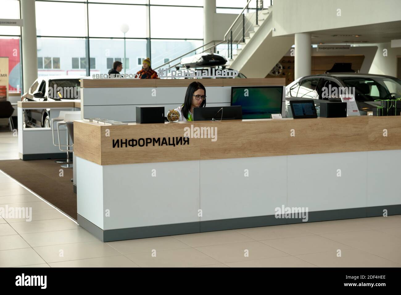 A girl sits at the reception desk, with an inscription in Russian ...