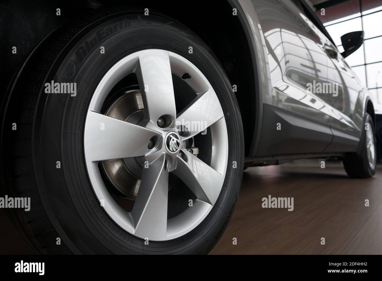 The rear of a shiny new car with a wheel in the foreground Stock Photo ...