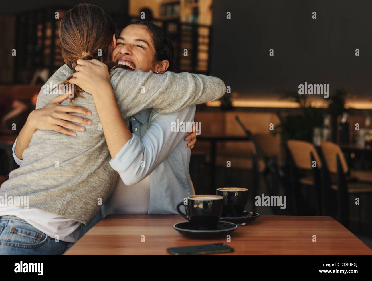 Happy meeting two friends hugging hi-res stock photography and images ...