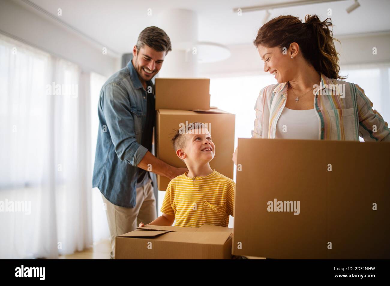 Happy family unpacking boxes in new home on moving day Stock Photo - Alamy