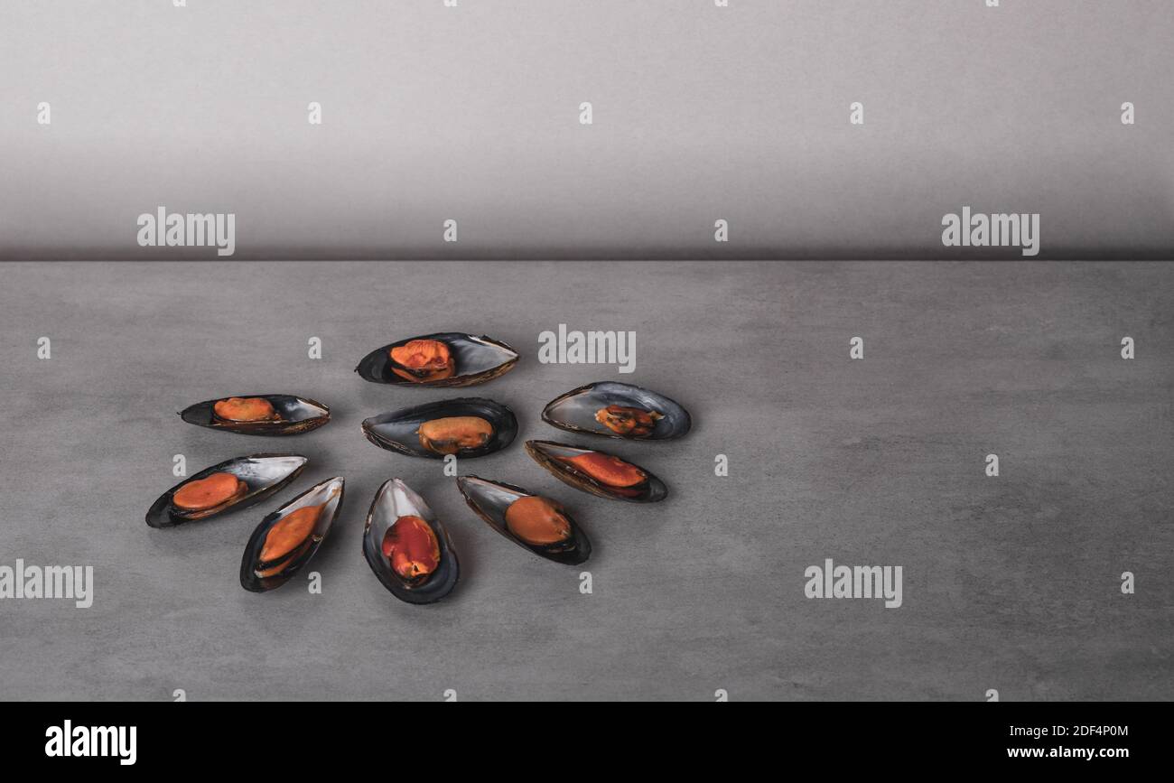 Seafood. The delicious, cooked mussels on a grey stone background ...