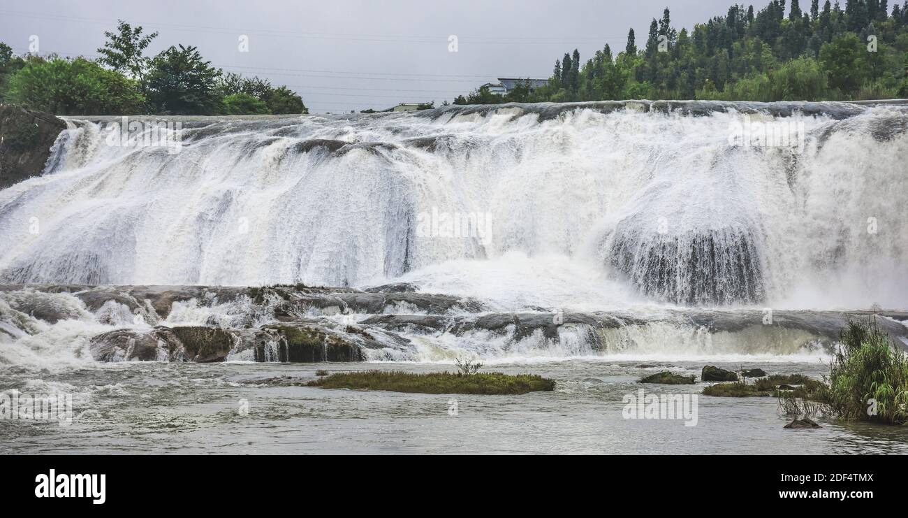 The waterfall interrupts violently the peaceful continuous flow of the ...